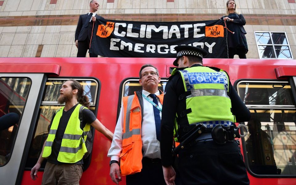 Climate change protesters glue themselves to DLR train at Canary Wharf ...